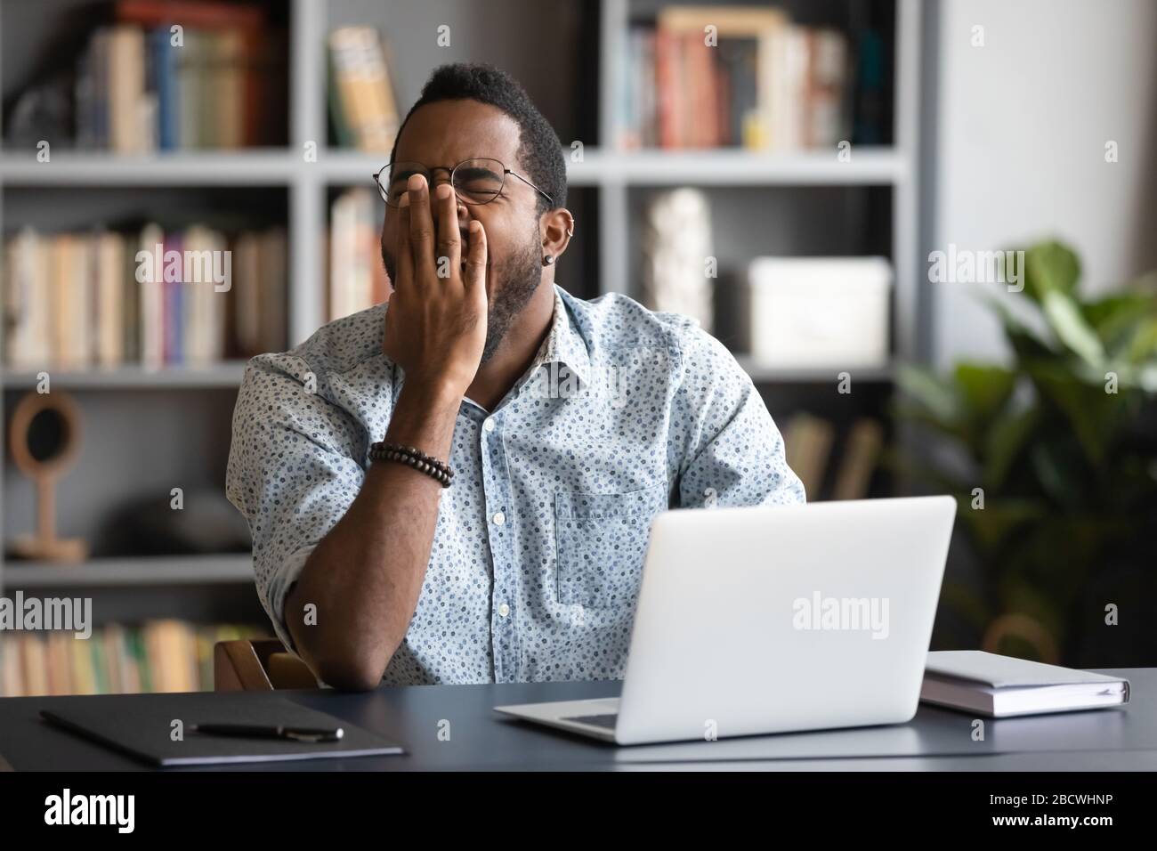 Tired african American male employee feel fatigue at workplace Stock ...