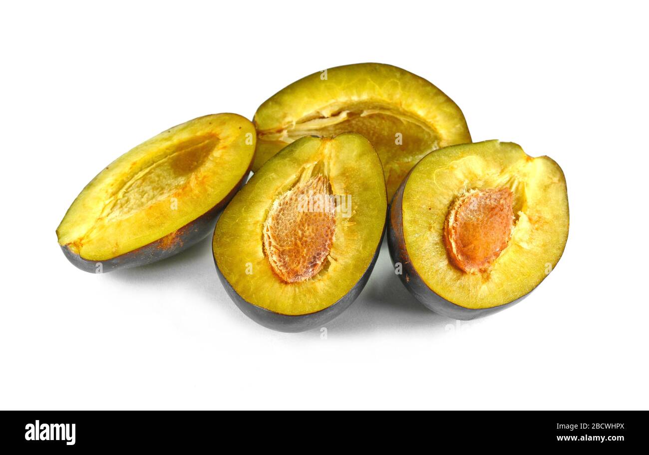 Plums cut in half isolated on white background Stock Photo - Alamy