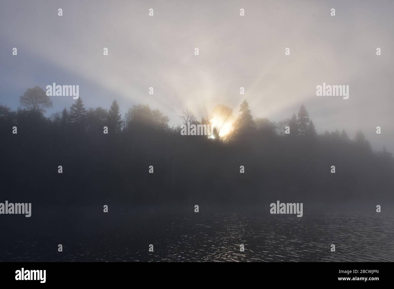 Sun rising over the water Stock Photo - Alamy