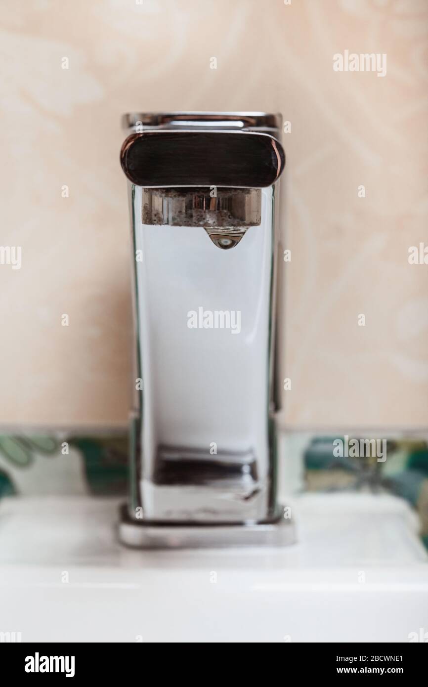Drop of water flows from the tap Stock Photo - Alamy