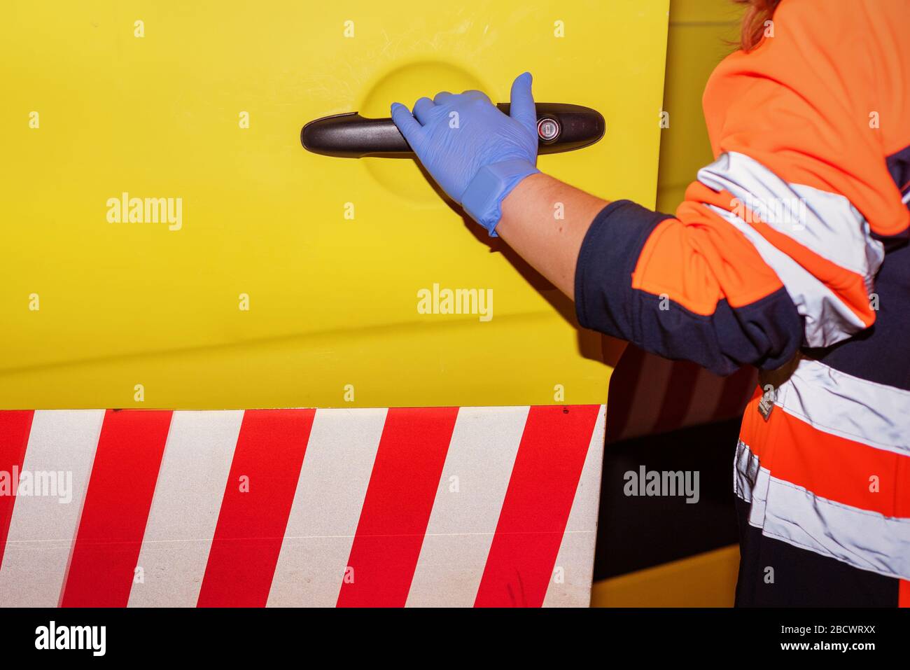 Night scene of an unrecognizable Paramedic at work, opening Ambulance ...