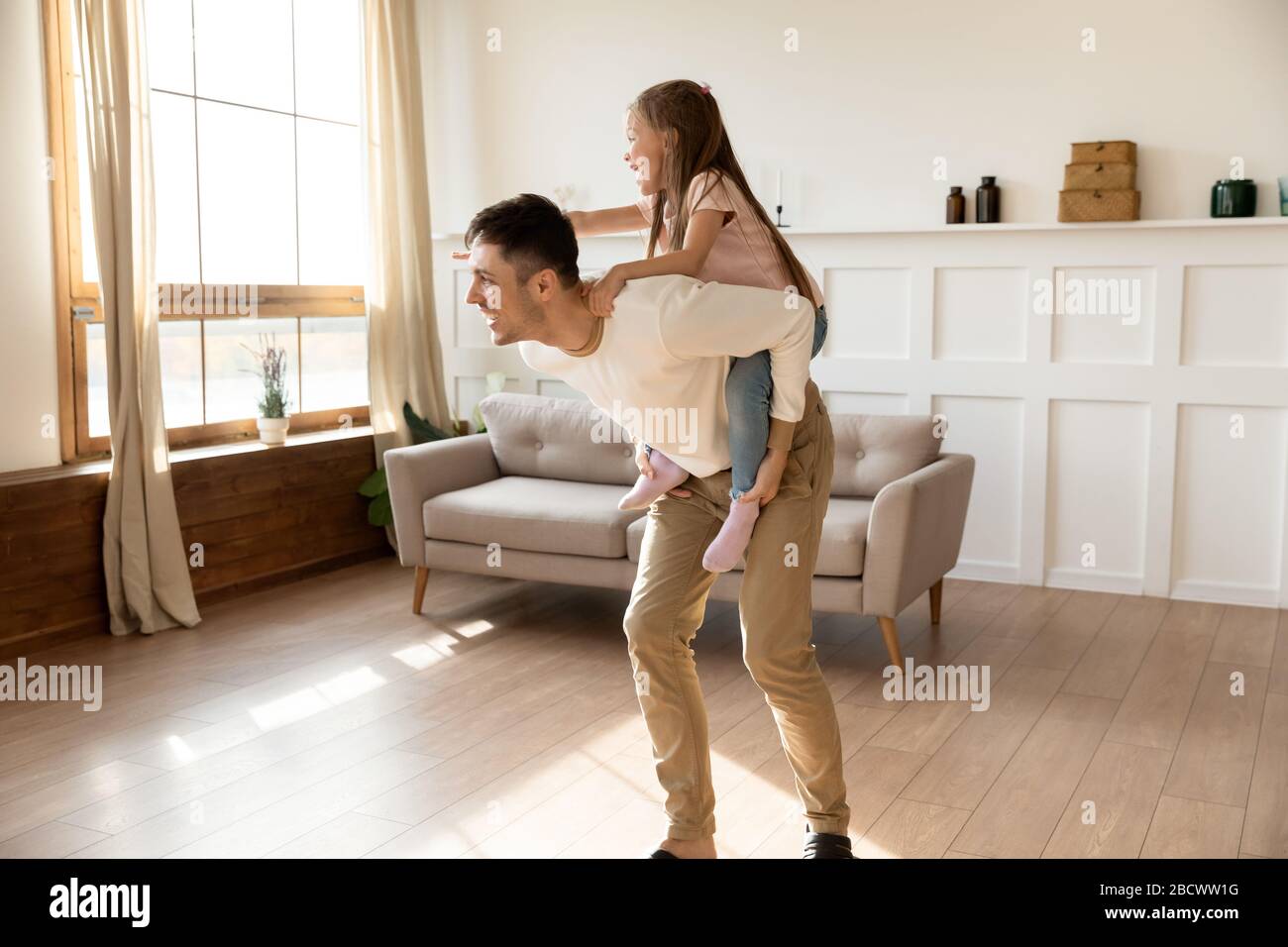 Happy father giving piggyback ride to overjoyed little daughter Stock ...