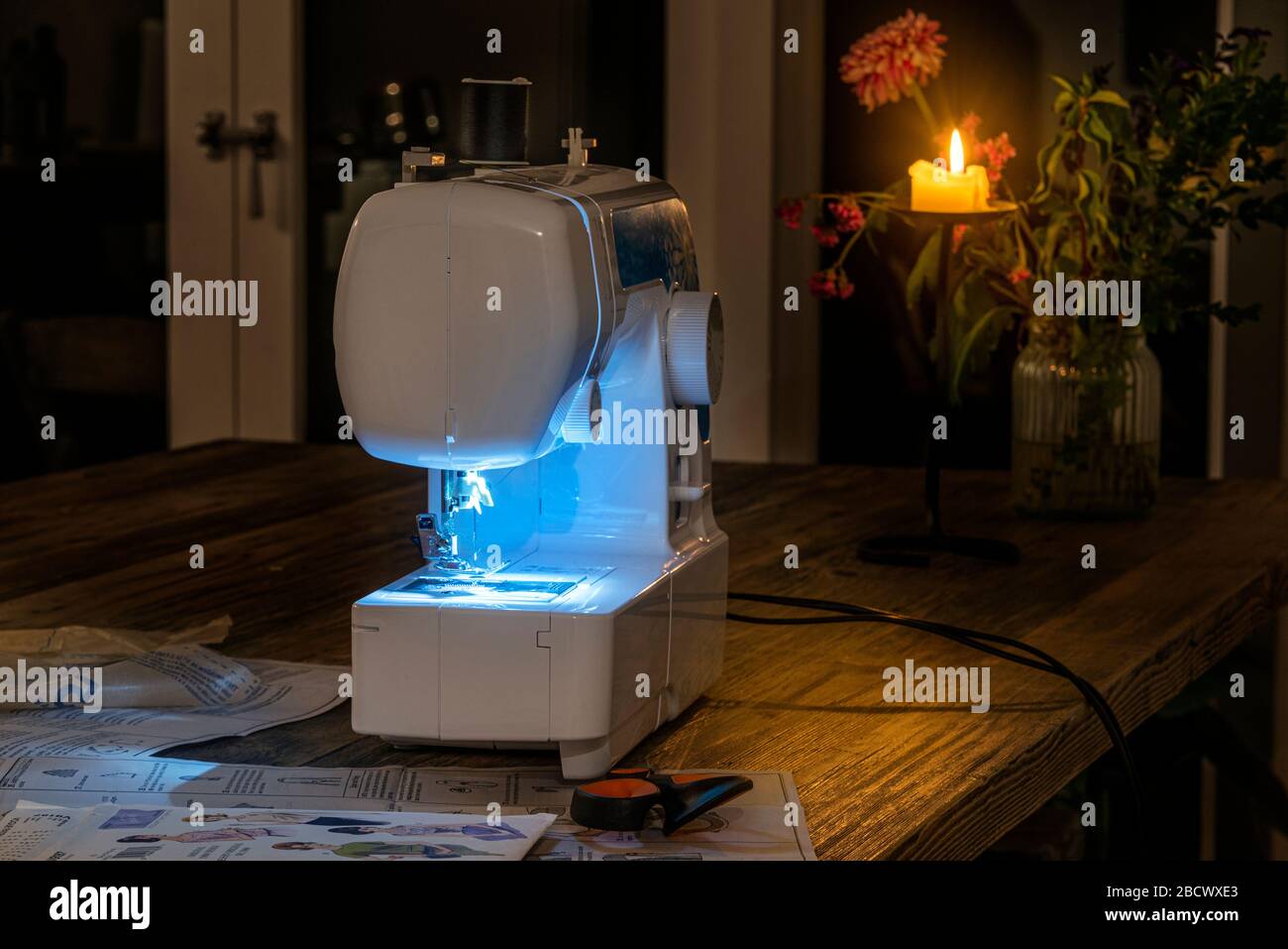 Covid 19 activities. Close up of a sewing machine at night, illuminated ...