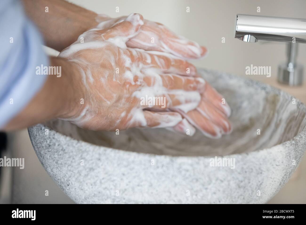 Young responsible caucasian man cleaning hands with antibacterial soap ...