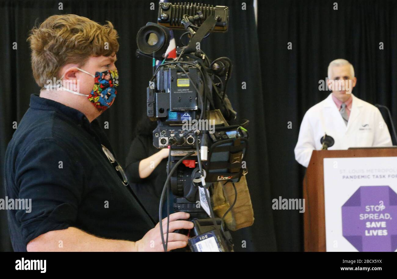 A television photographer monitors his equipment, wearing a colorful ...