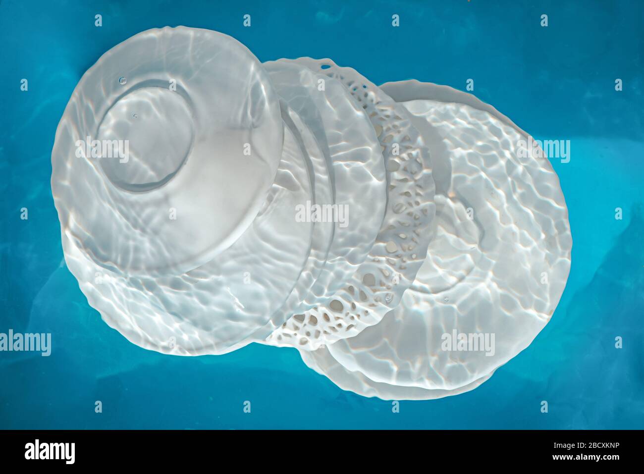 Porcelain plates and dishes soaked in water with waves and ripples ...