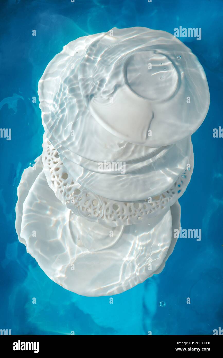 Porcelain plates and dishes soaked in water with waves and ripples ...