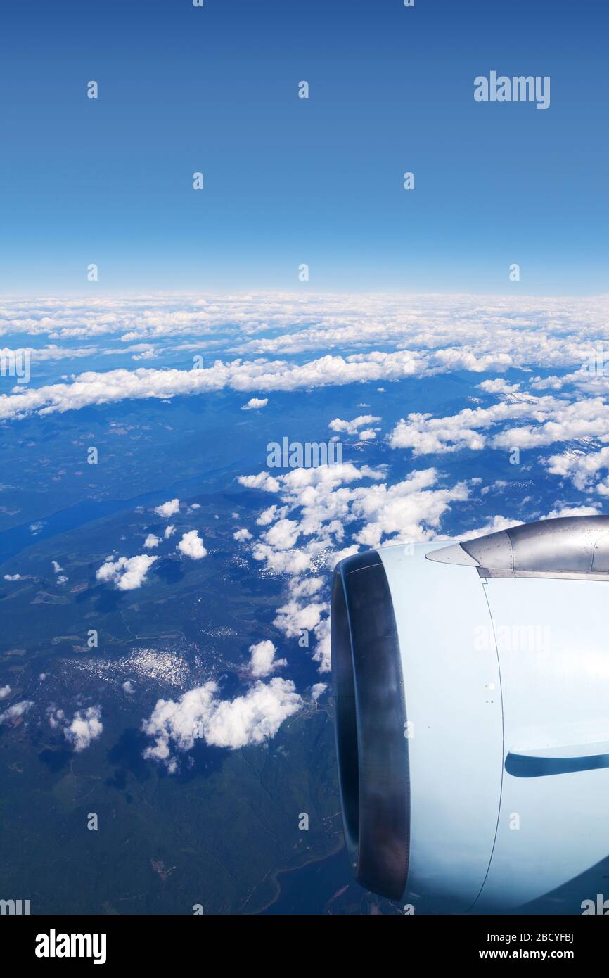 View from airplane window showing plane engine over the clouds ...