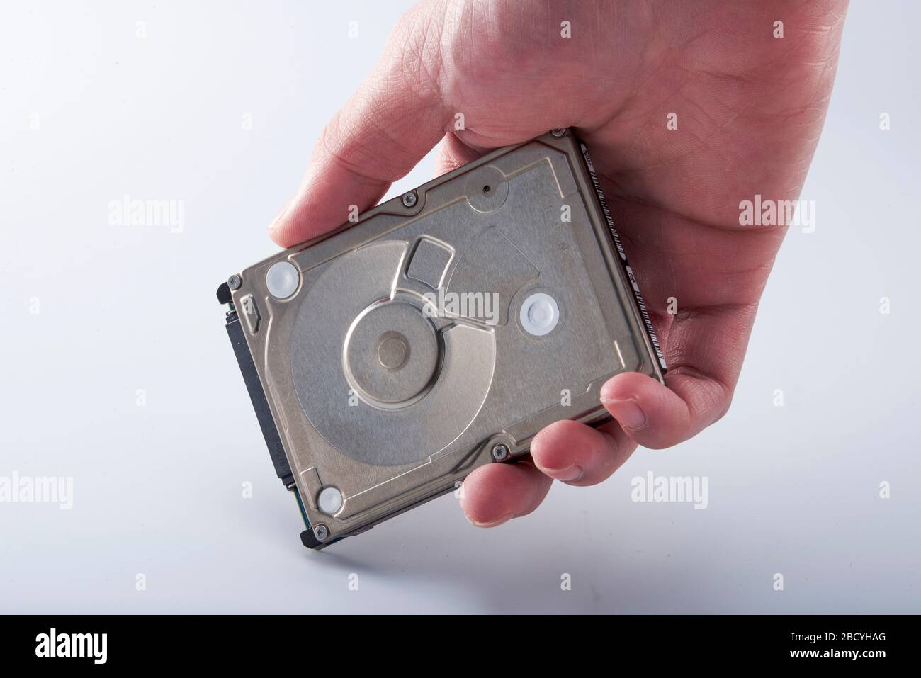 One hand picks up 2.5-inch computer mechanical hard drive Stock Photo ...