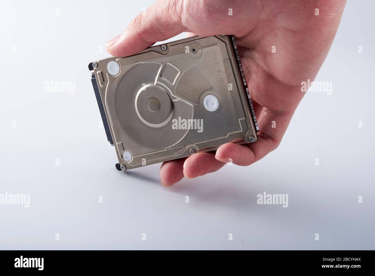 One hand picks up 2.5-inch computer mechanical hard drive Stock Photo ...