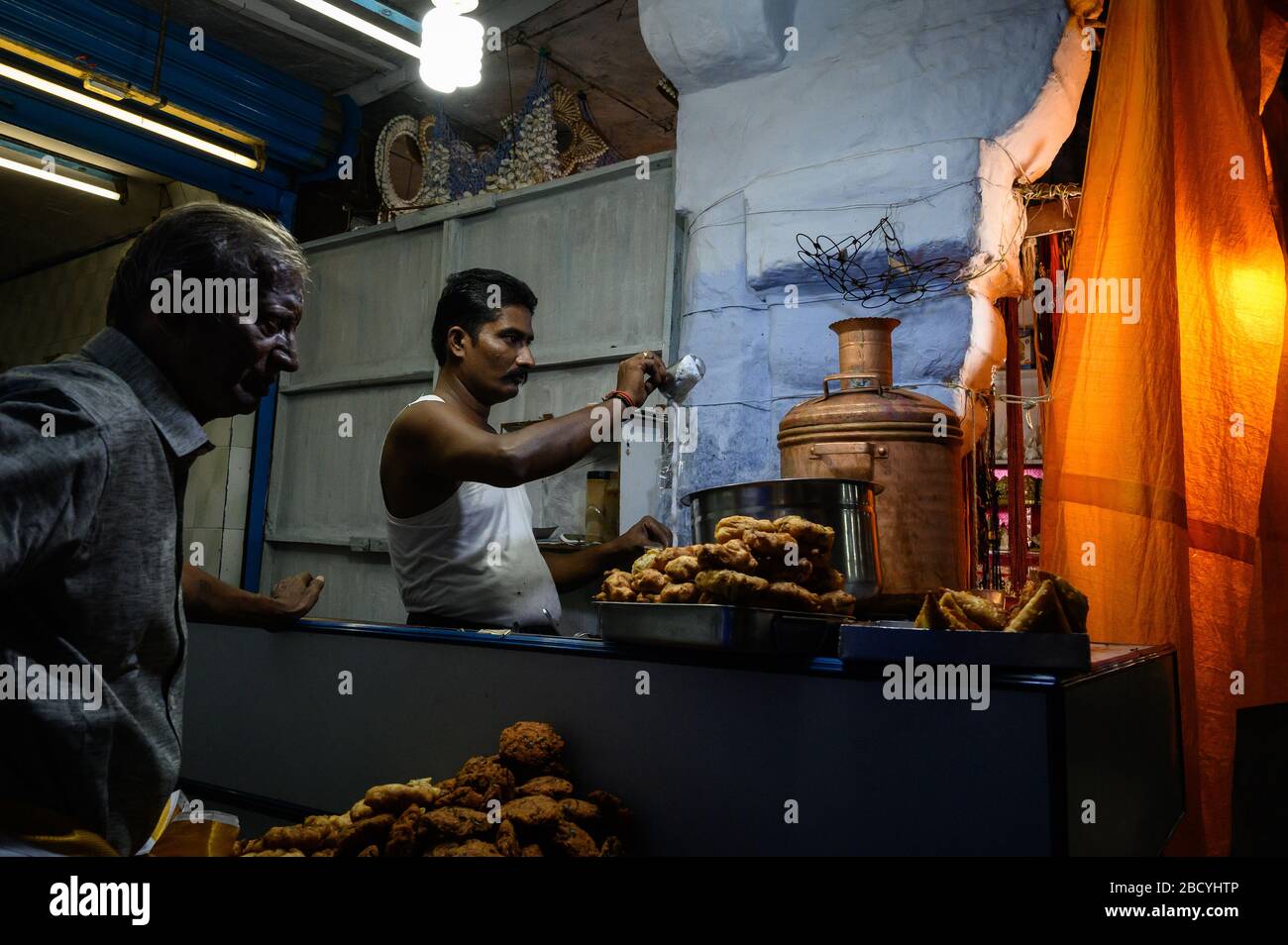 A man making tea in his shop near the grounds of Tiruchendur Murugan ...