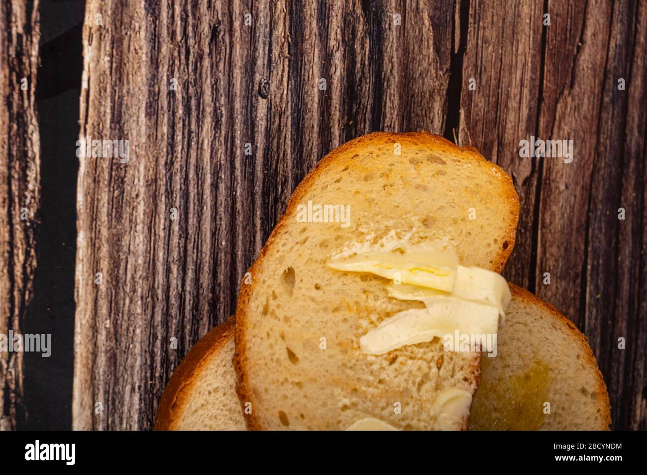 Fresh wheat toast with butter on a wooden background. Close up Stock ...