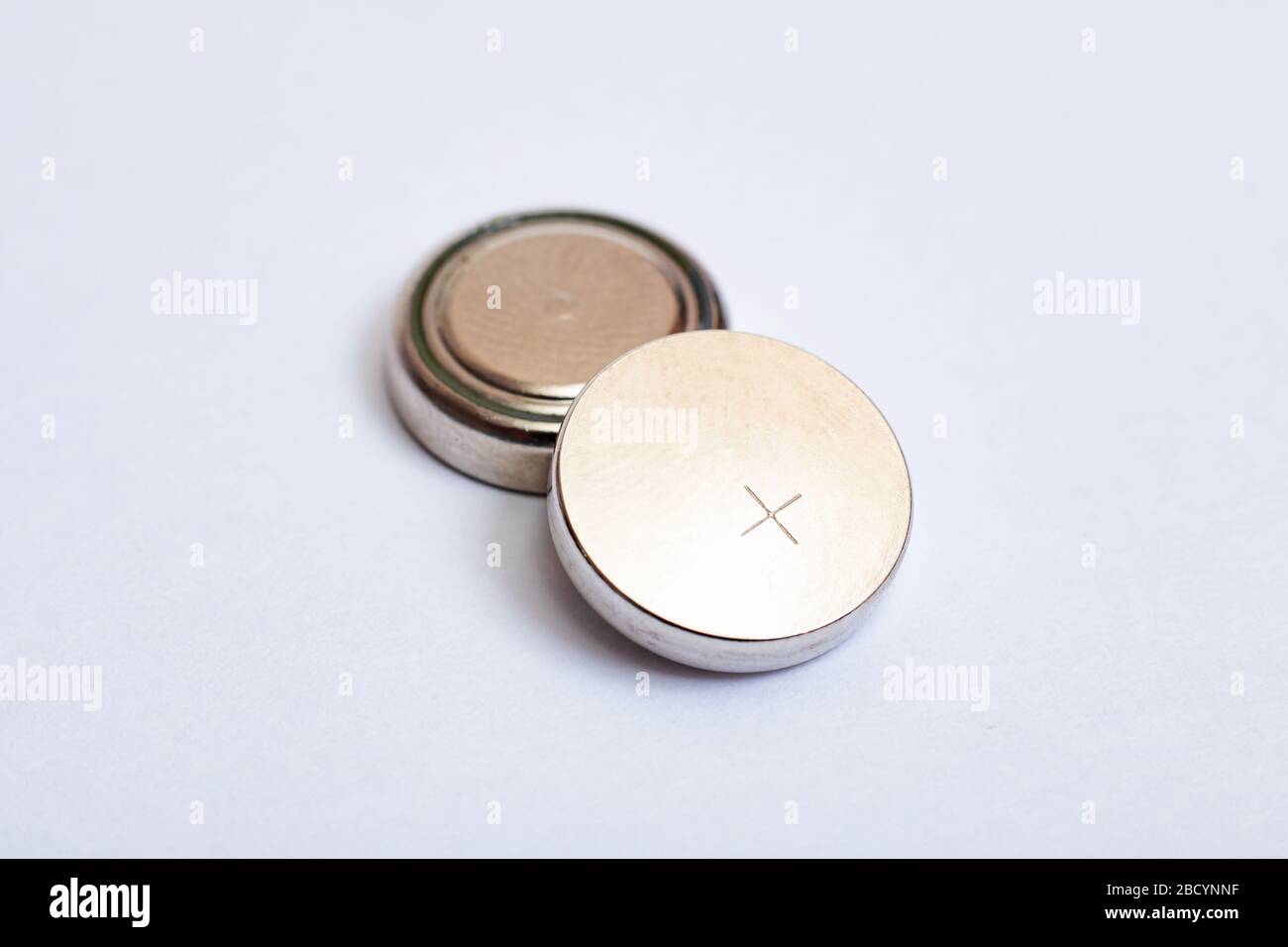 Two round batteries on a white background close up Stock Photo - Alamy