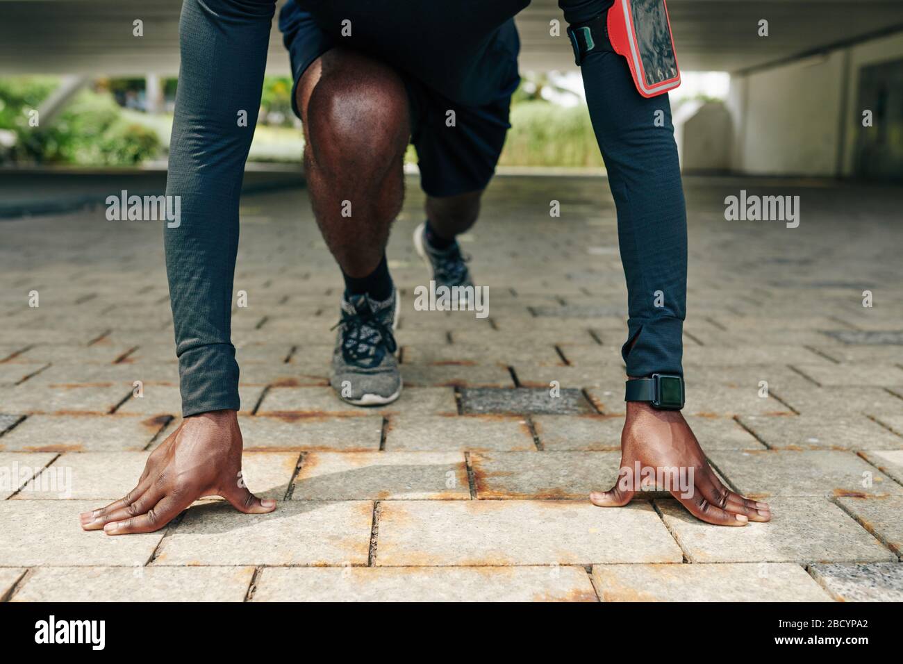 Fit and confident male athlete in starting position ready to start a ...