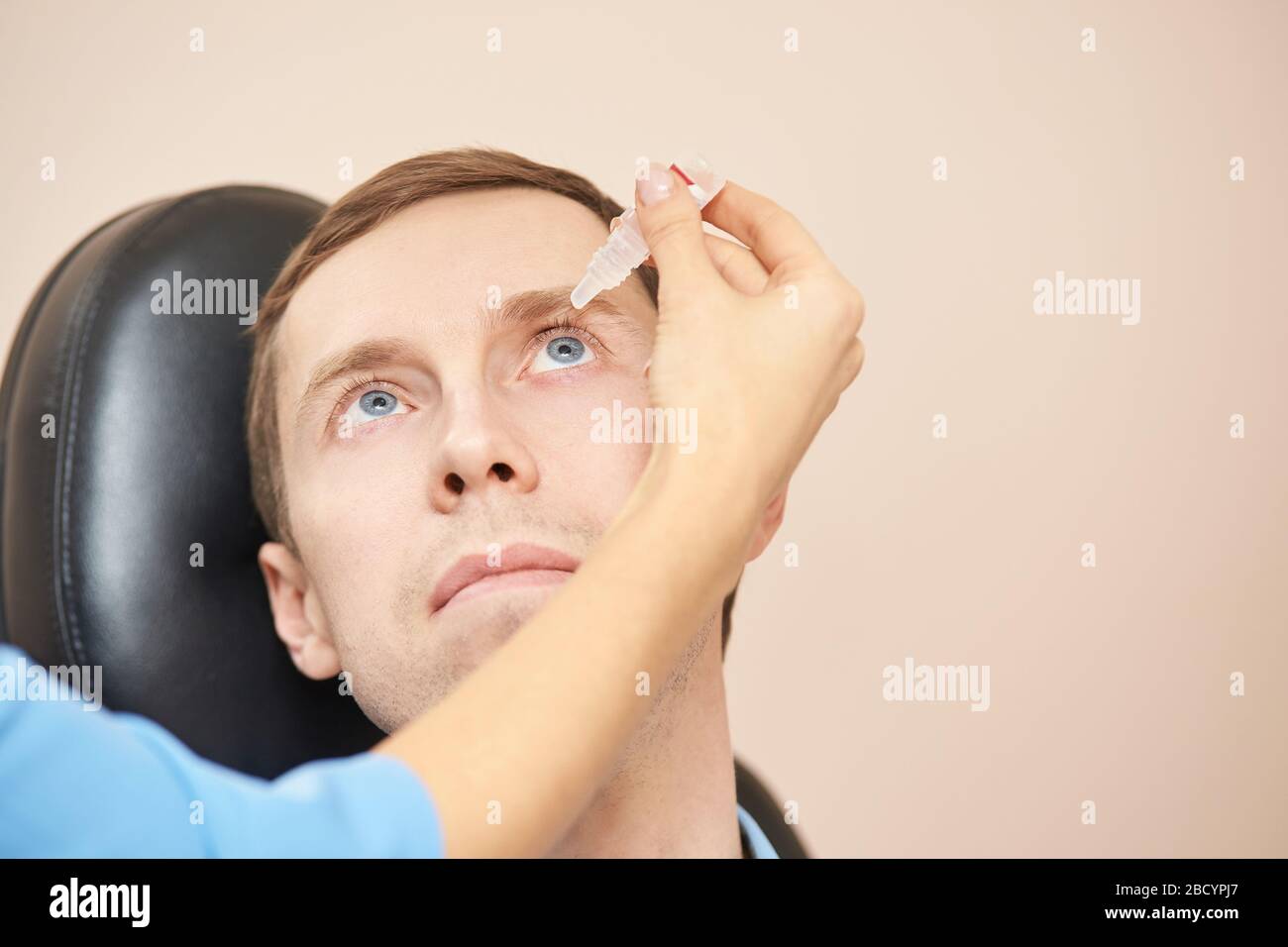 Doctor hold eye drops near patient face Stock Photo - Alamy
