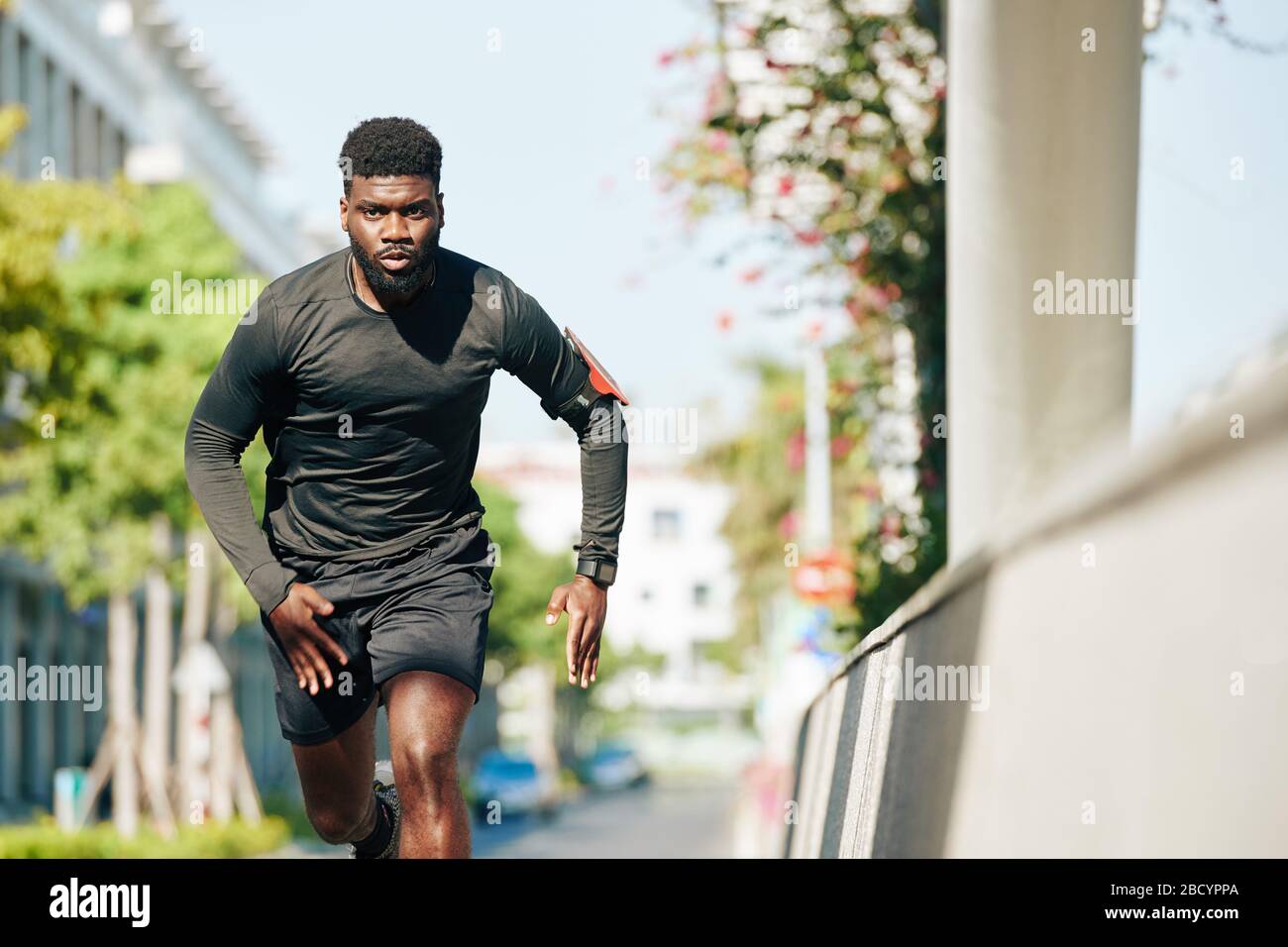 Serious concentrated Black young man running in the street when ...