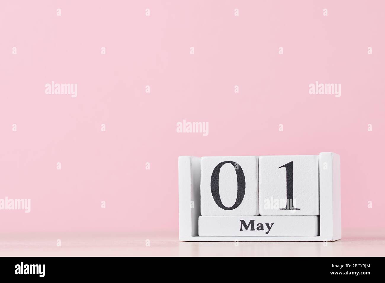 Wooden block calendar with date May 1 on pink background. Labor Day ...