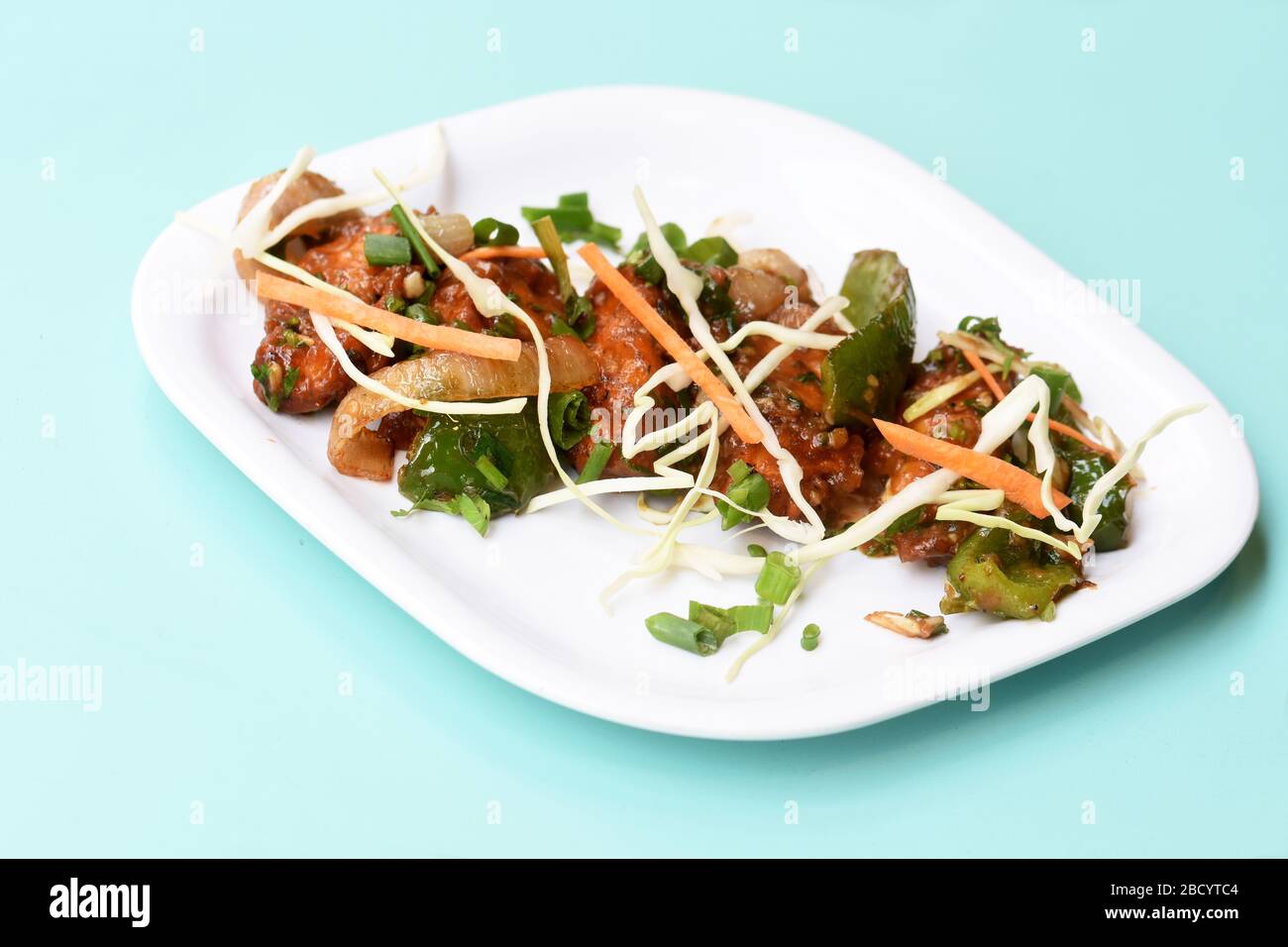 chilli paneer or Spicy cottage cheese, Garnish with capsicum, onion ...