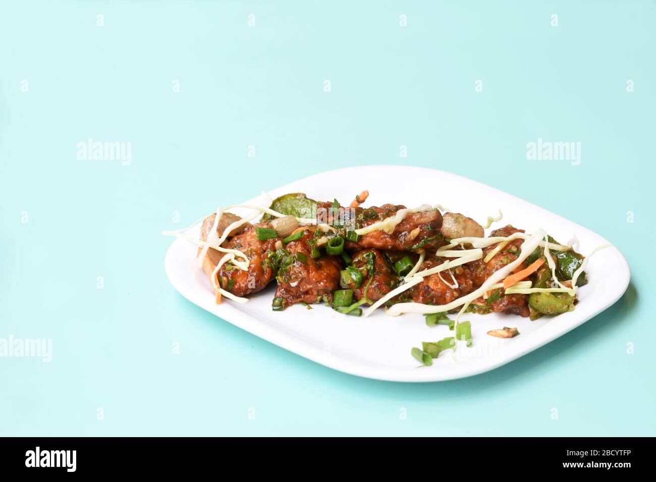 chilli paneer or Spicy cottage cheese, Garnish with capsicum, onion ...