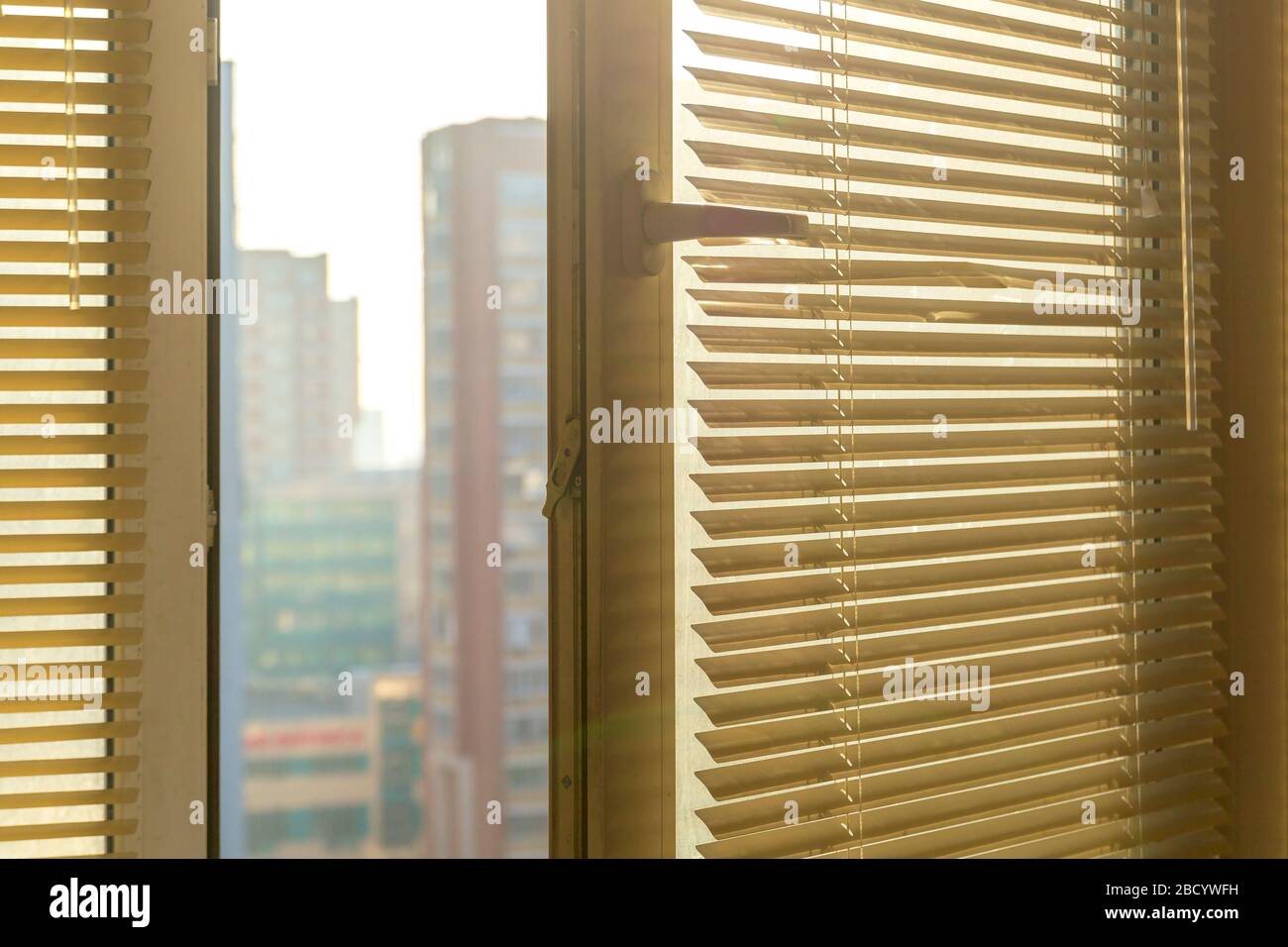 Open window with shutters in an apartment with blurred city views in ...