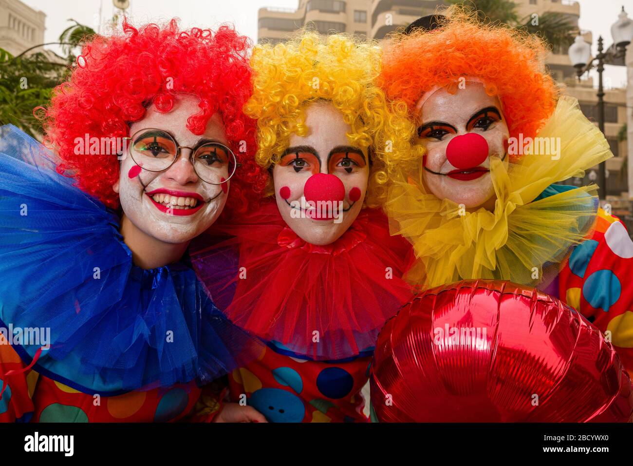 A group of women, dressed up as clowns and smiling, partying in the ...