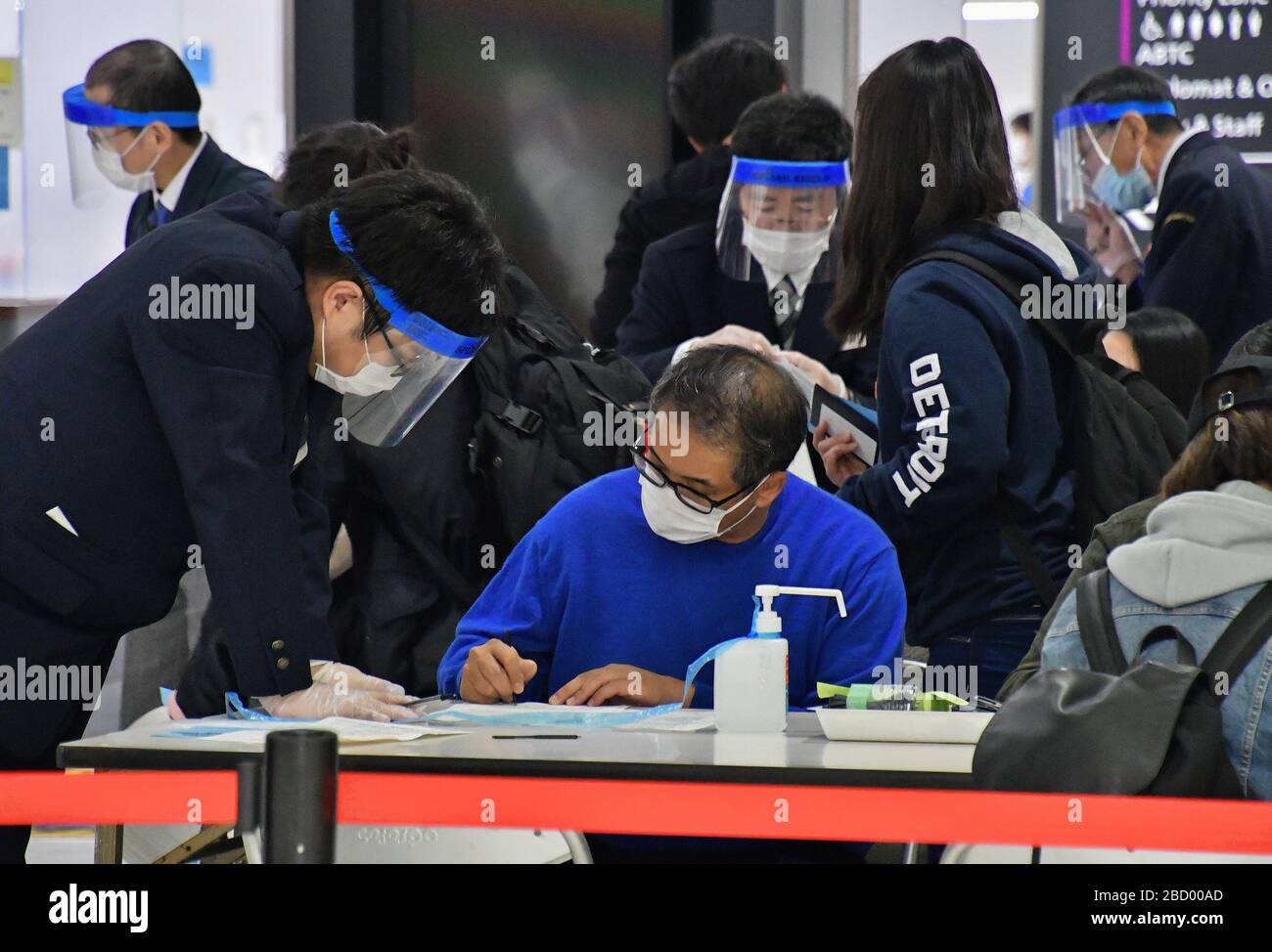Quarantine officers wearing face masks and face shields assist ...