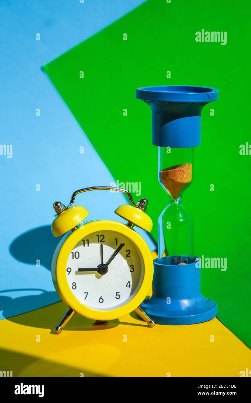 classic desktop clock, Hourglass colored background on yellow, green ...