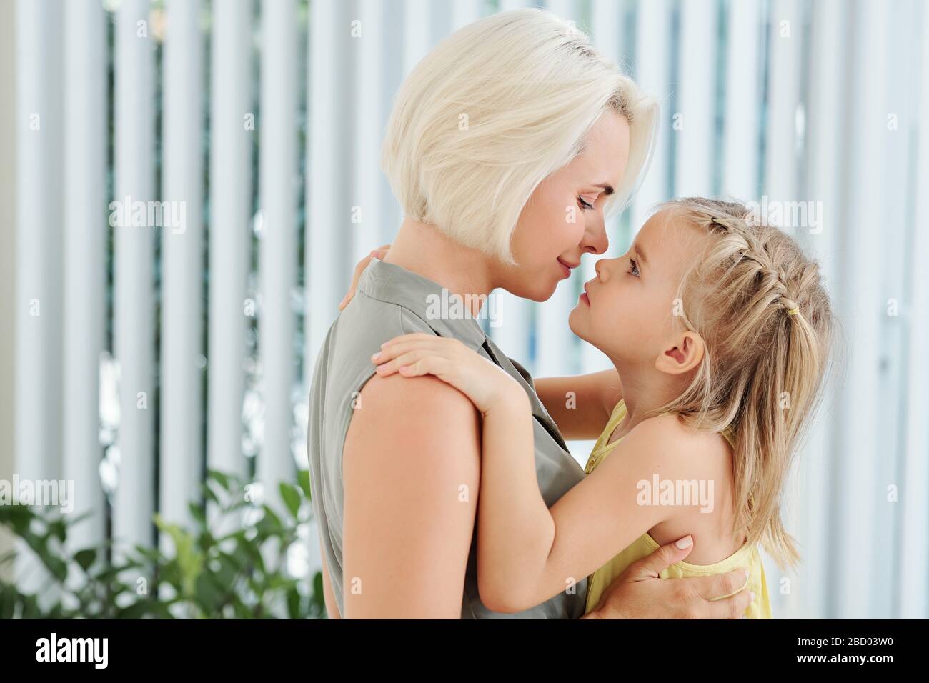 Hugging happy mother and her adorable pretty little daughter looking at each other Stock Photo ...