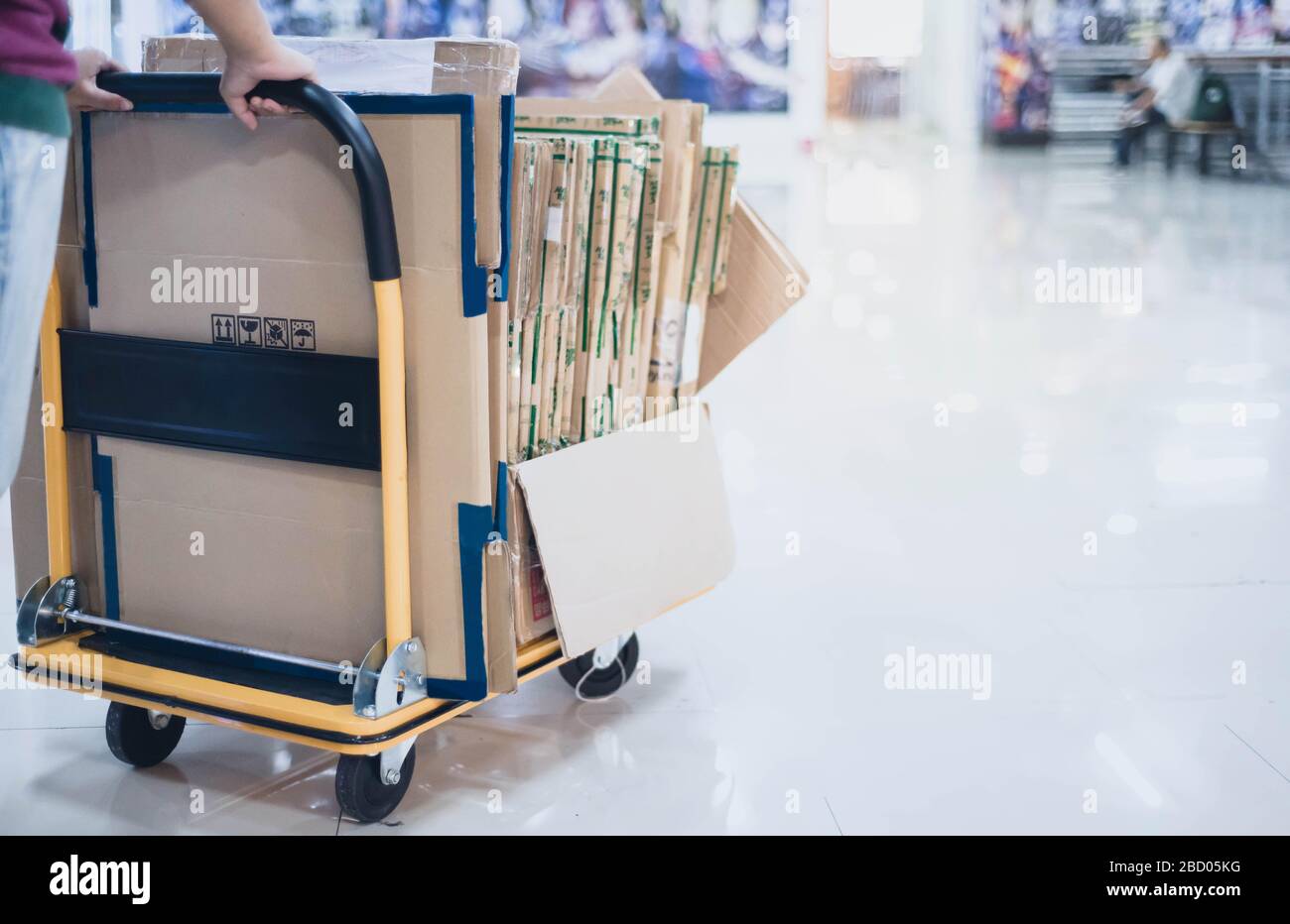 Male hand pushing the brown box put on the box cart for Delivery ...