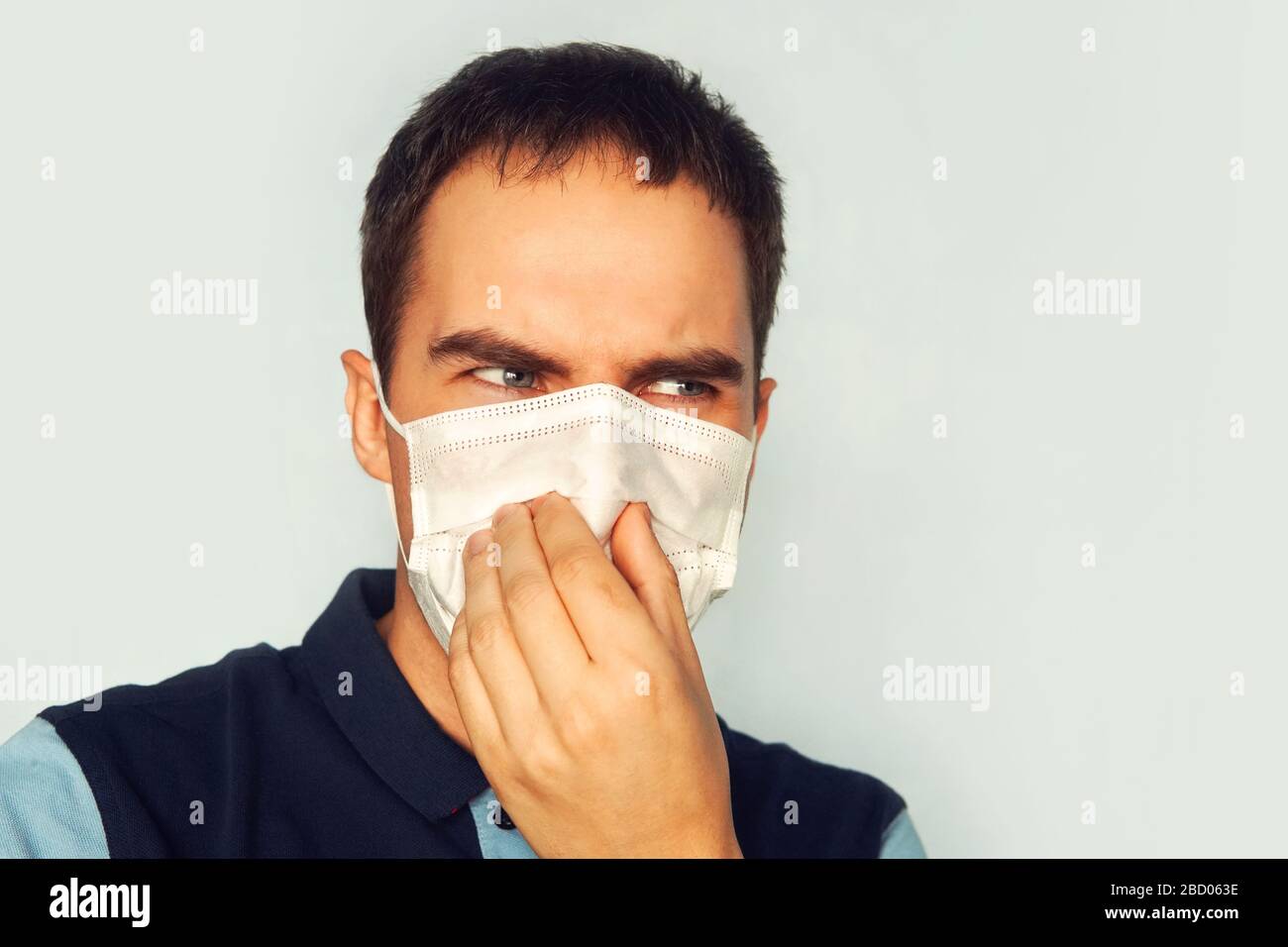 Portrait of a Male wears blue medical face mask. blue background. Fear ...