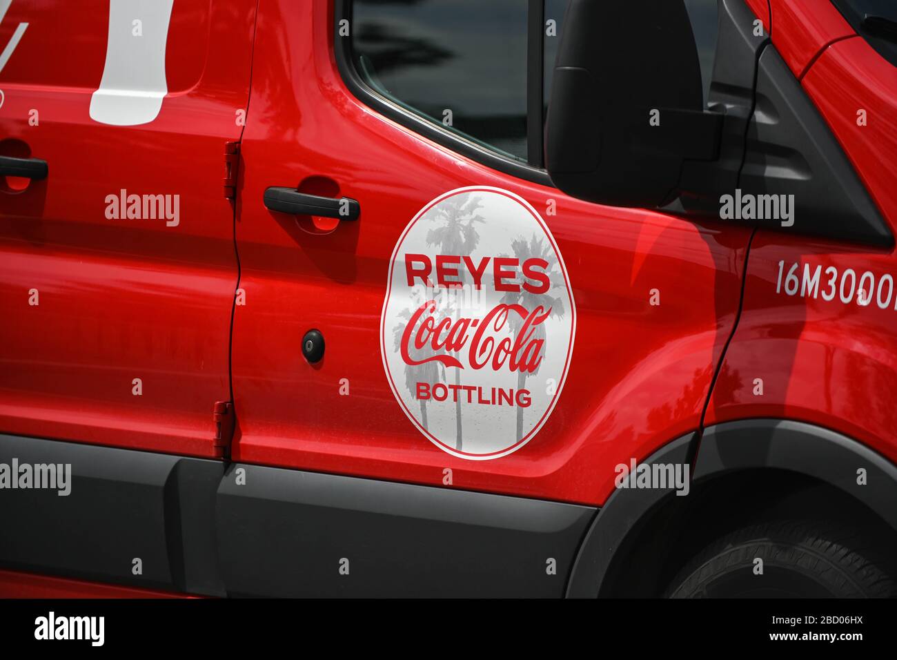 Vans branded with Coca-Cola logos sit outside a Coca-Cola Bottling ...