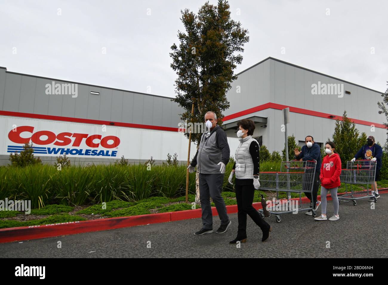 People wait outside a Costco Wholesale that opened early to cater to ...