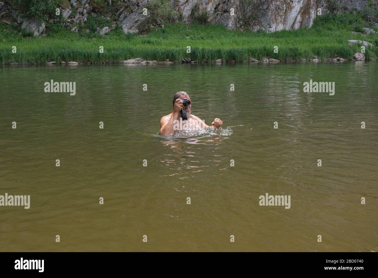 man aged plunged into the water looking or peeping through waterproof ...