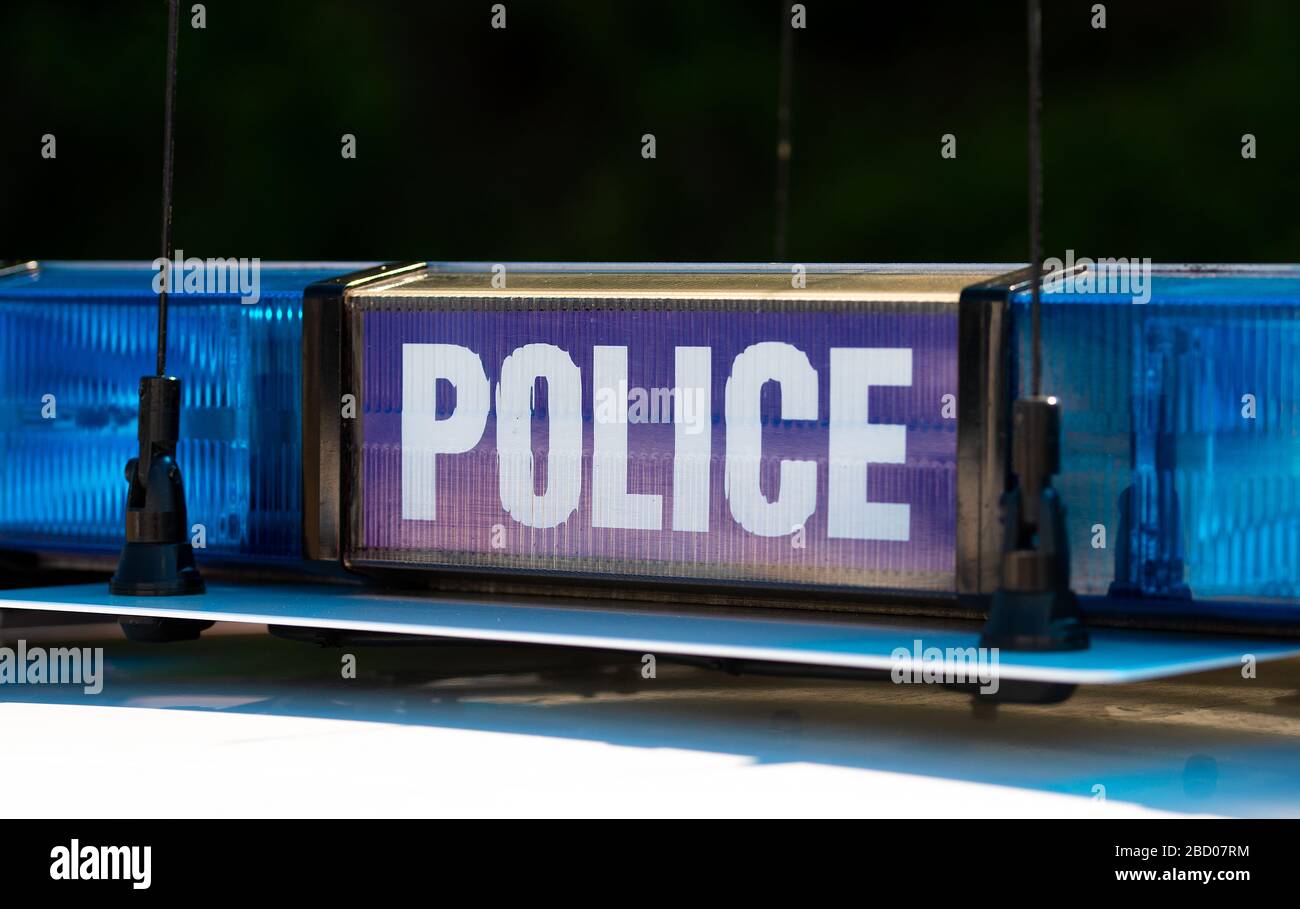 Police sign with blue lights, atop an emergency response patrol vehicle ...