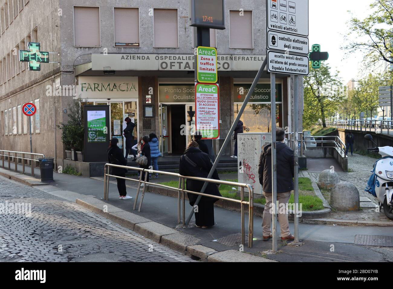 Queueing outside a pharmacy in Milan. Customers waiting in line to ...