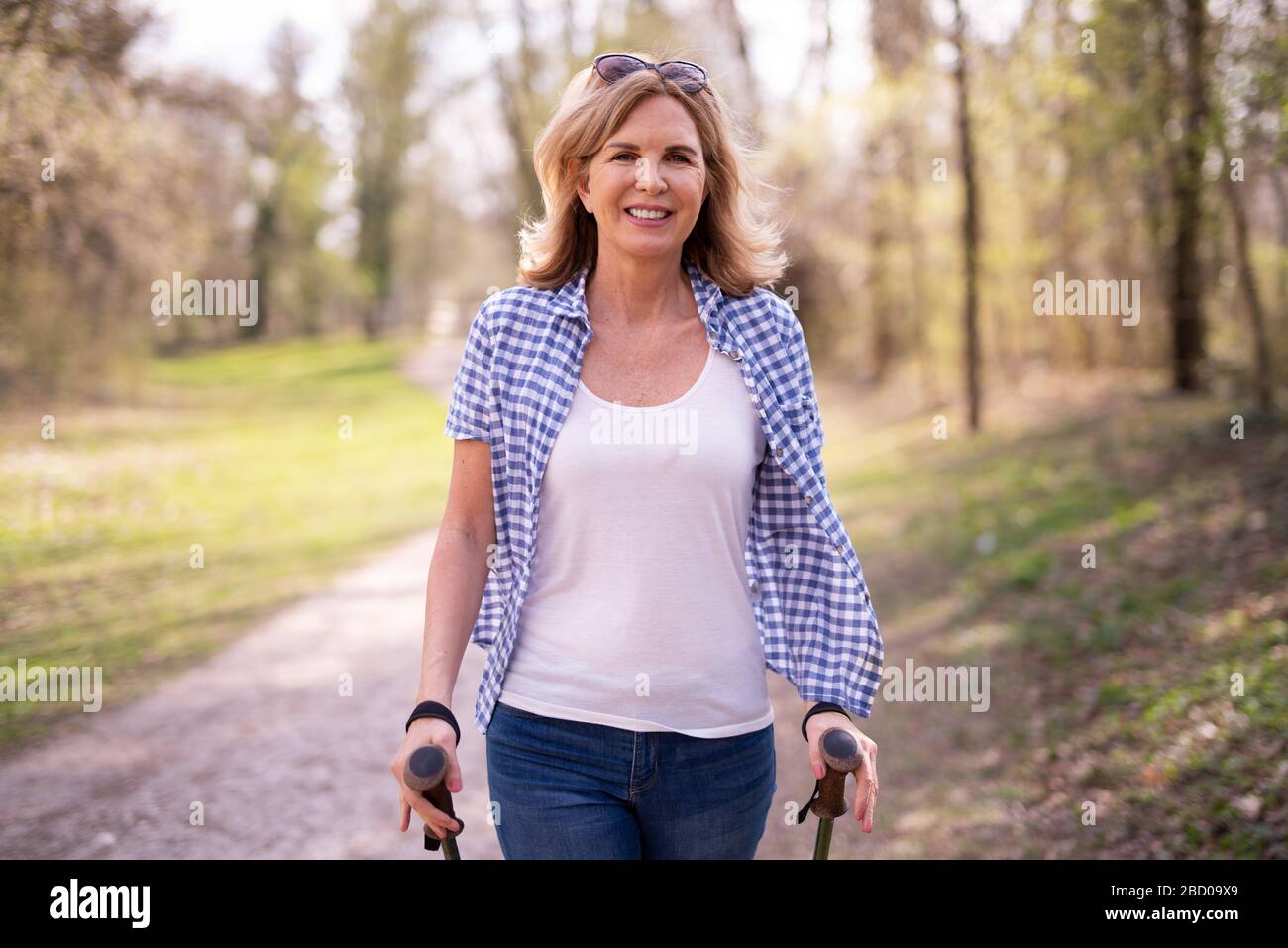 An attractive woman with a sympathetic laugh in nature while walking ...