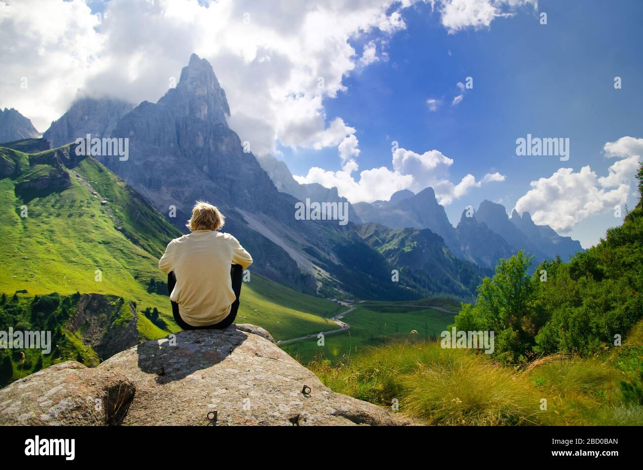 Man resting on the rock in Passo Rolle, - Italy , Dolomite. Scenery ...
