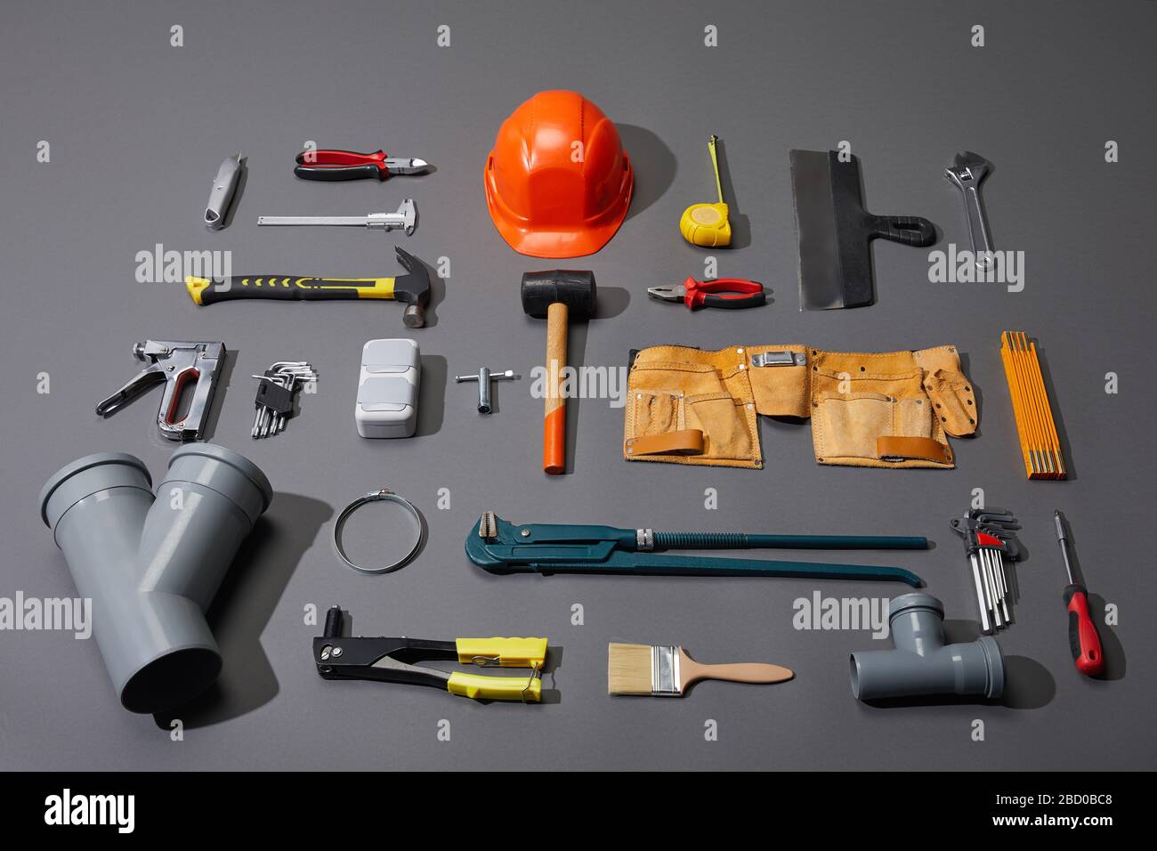 flat lay with industrial tools, helmet, and tool belt on grey ...
