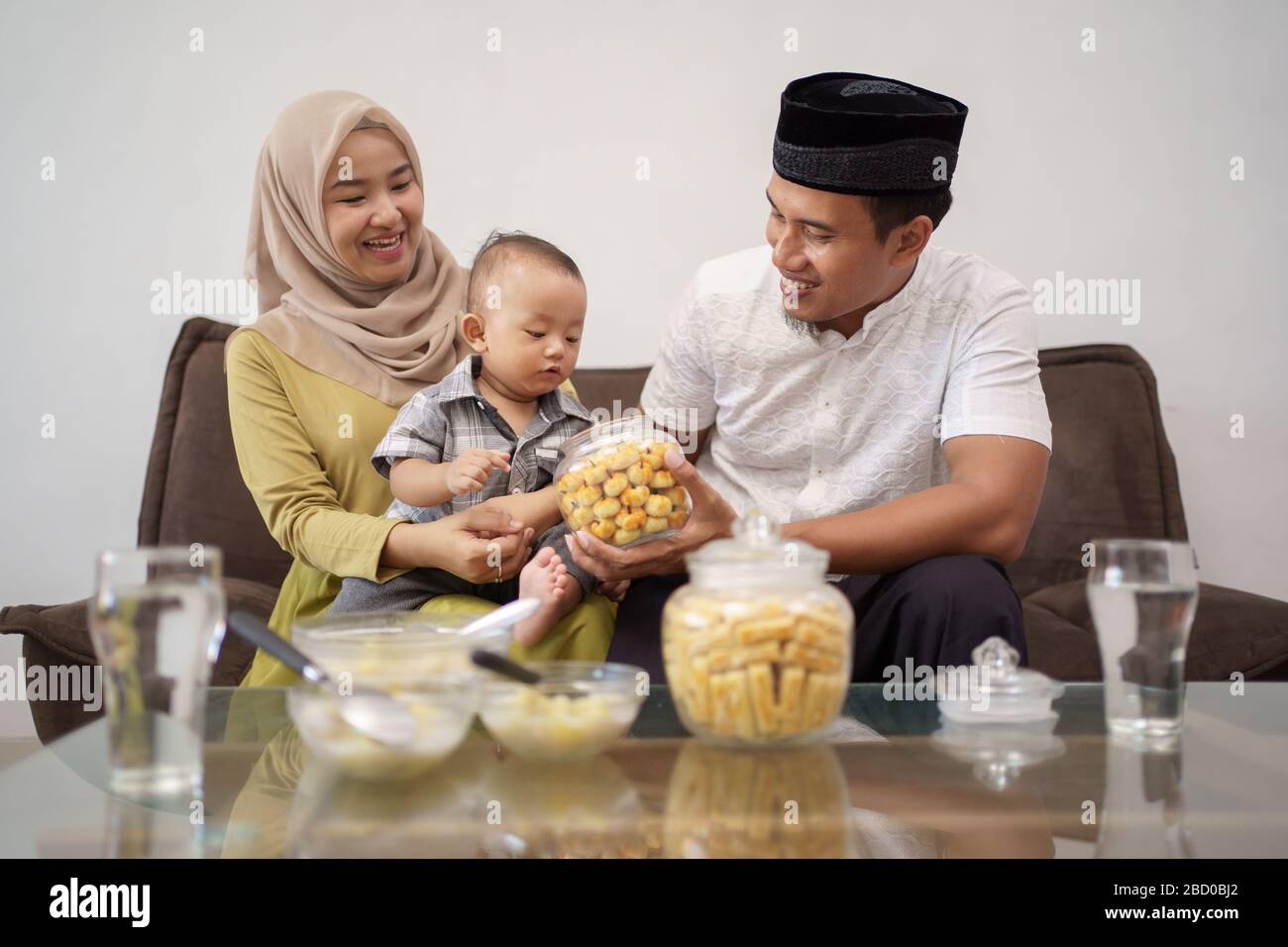 muslim family enjoy having some snack in the living room during hari ...