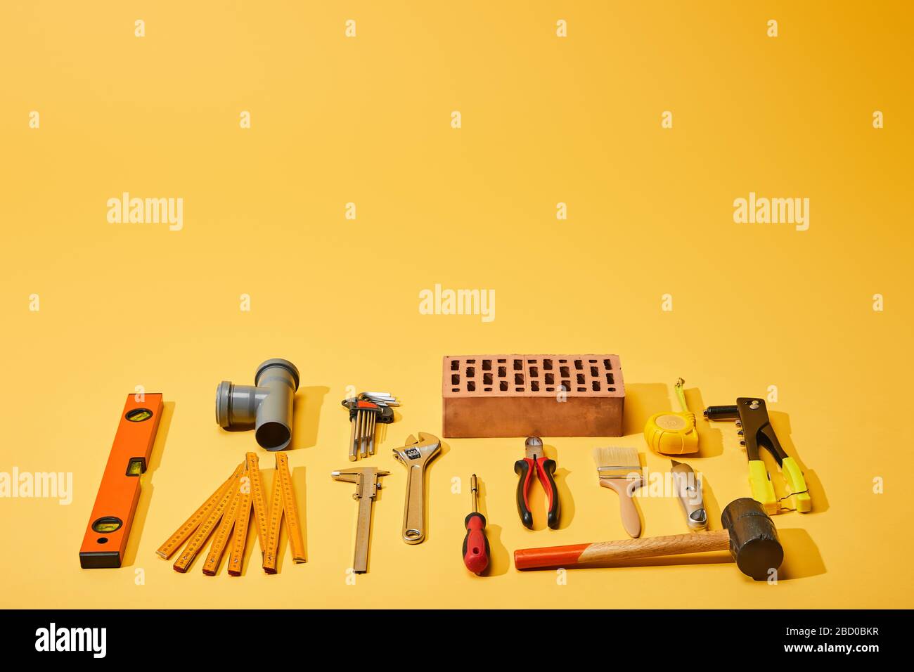 flat lay with industrial tools and brick on yellow background Stock ...