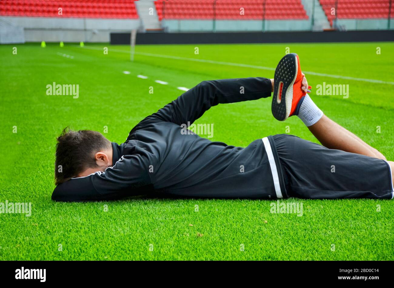 Stretching on green grass. Exercise photo, edit space. Professional ...