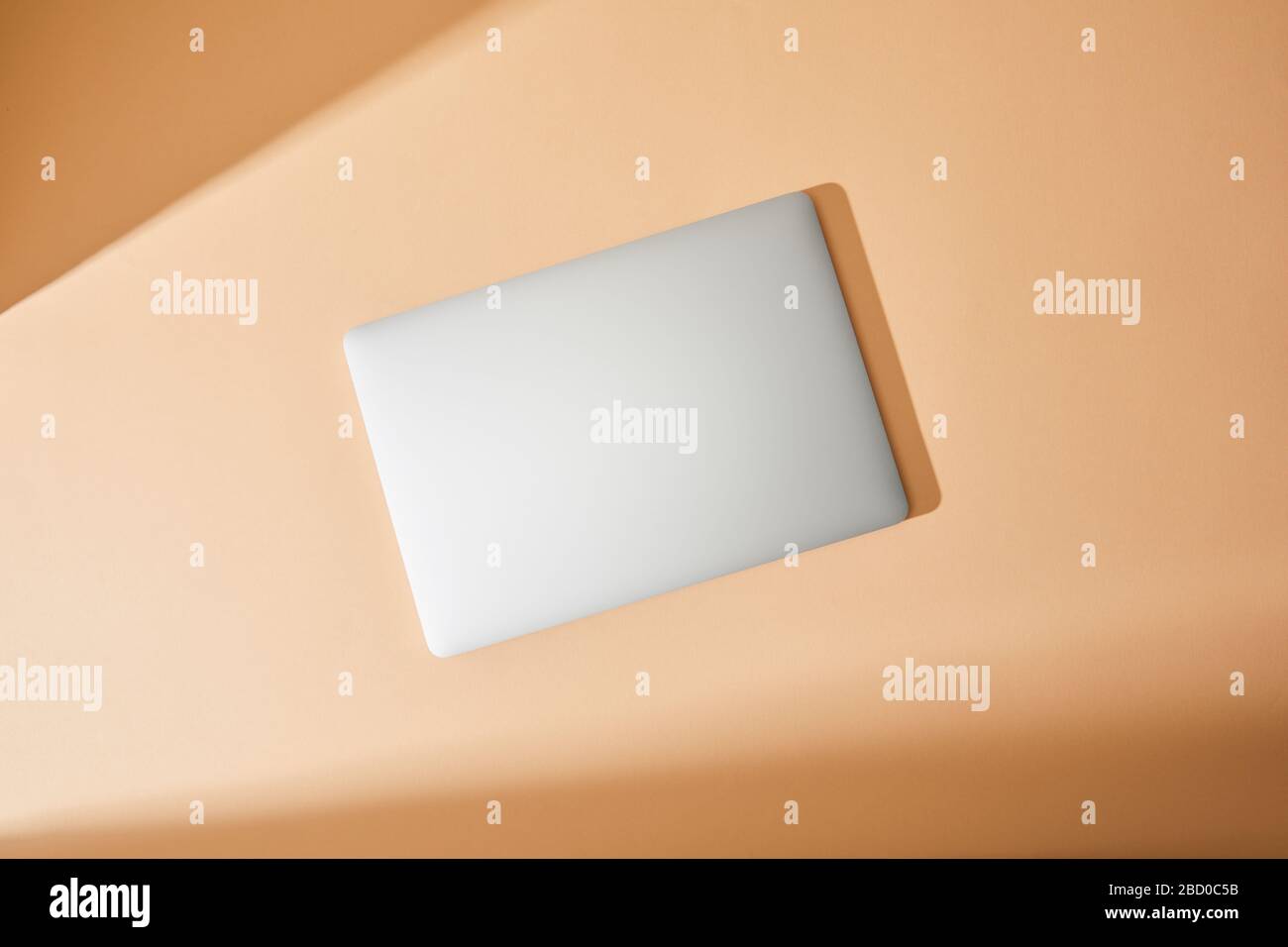 top view of closed white laptop on beige background Stock Photo - Alamy