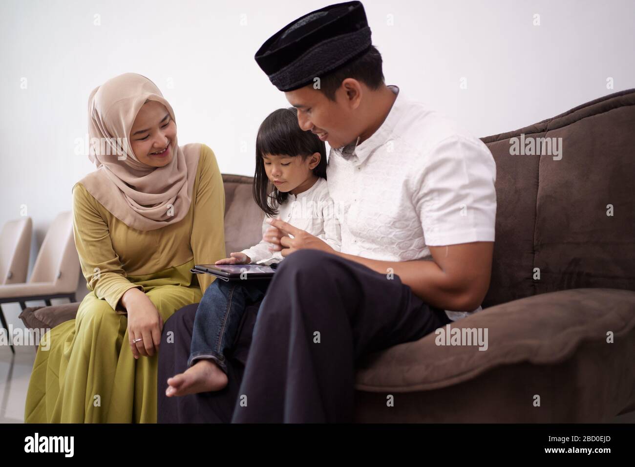 family working remotely from home sitting together using laptop and ...