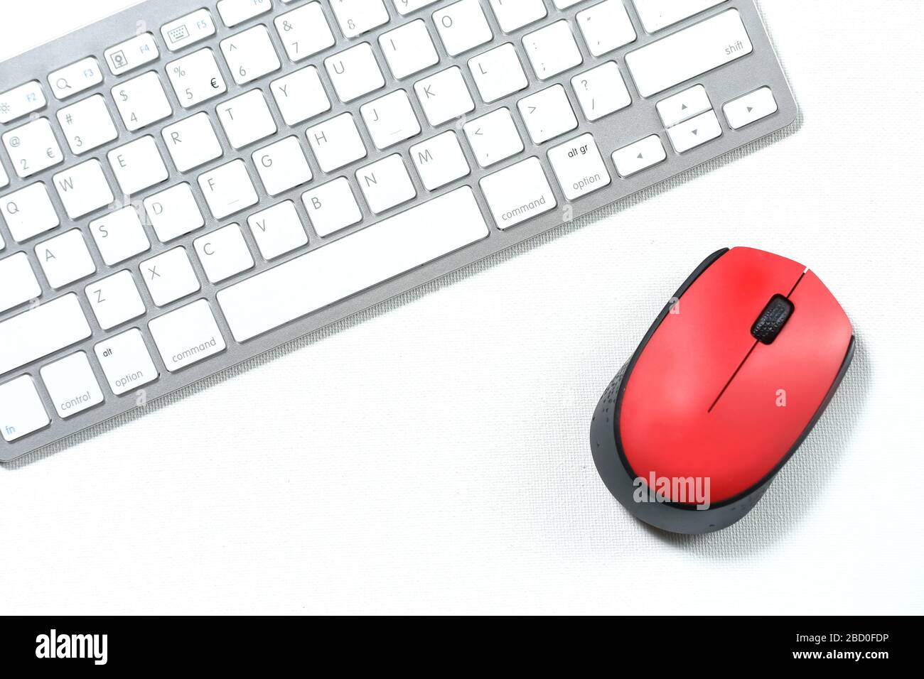 red mouse and white keyboard isolated on a white background ...