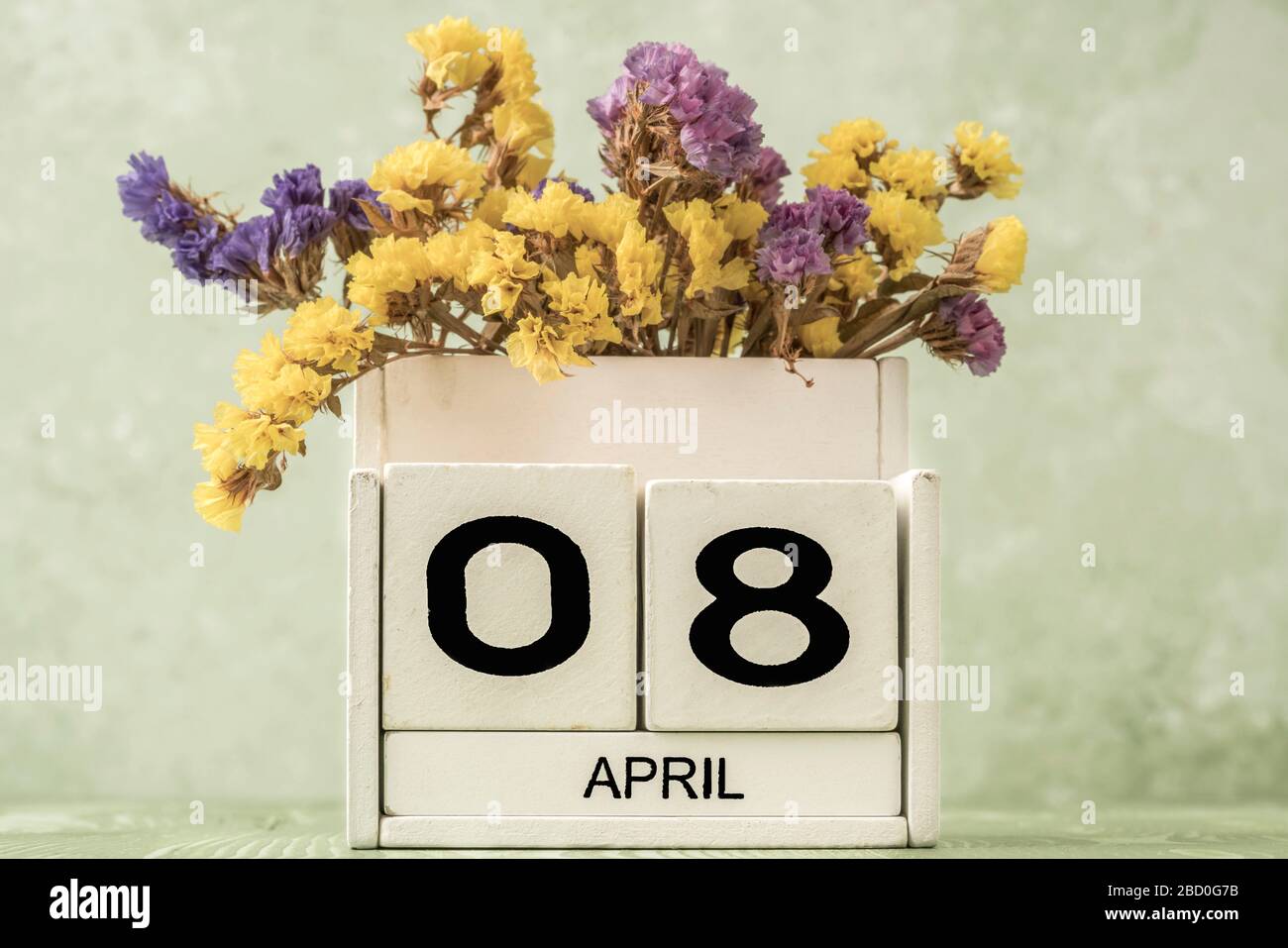 cube calendar for april decorated with flowers against green background ...