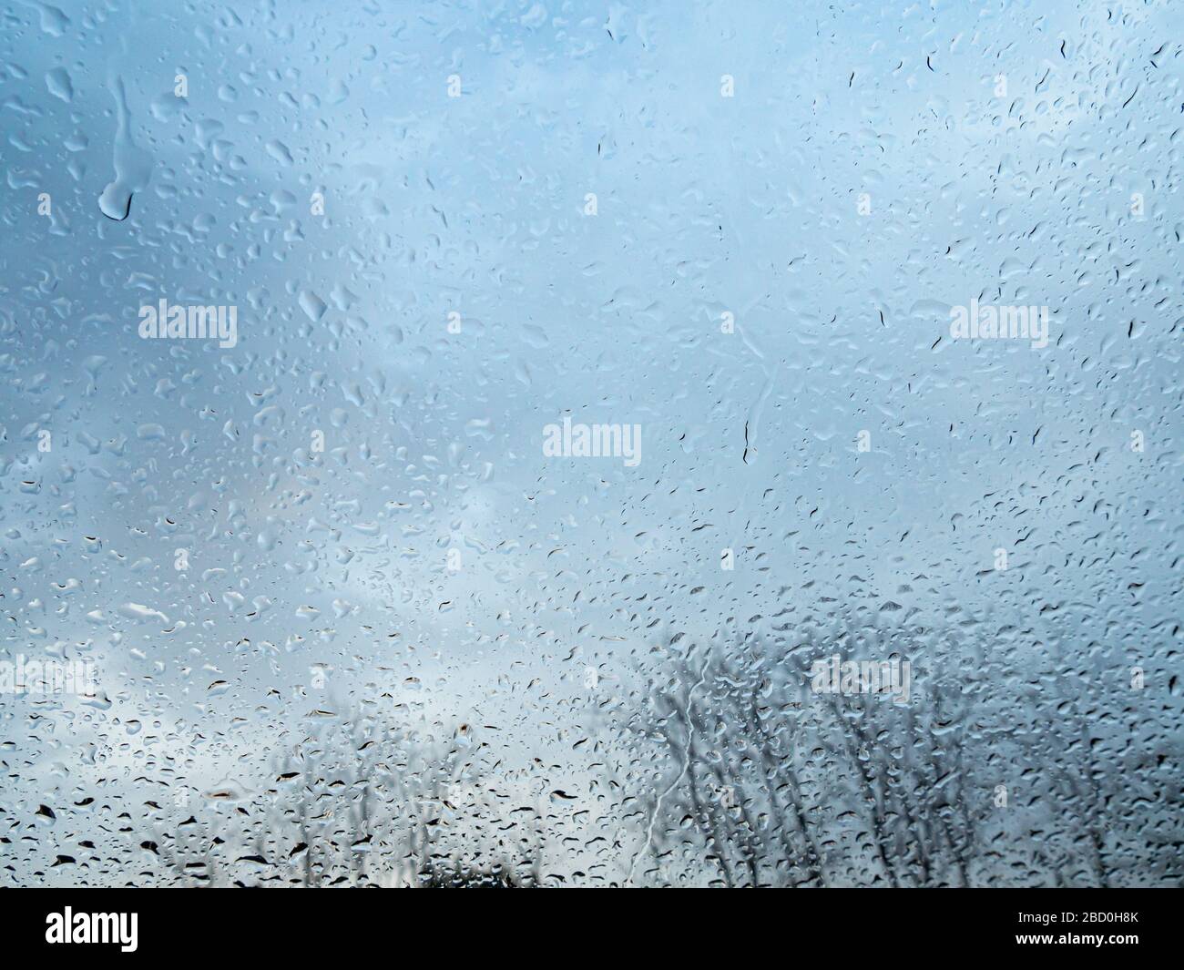 Wet window with rain drops and a cloudy sky outside background Stock ...