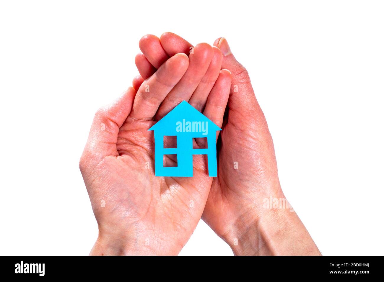 Person holds blue house with both hands isolated on a white background ...