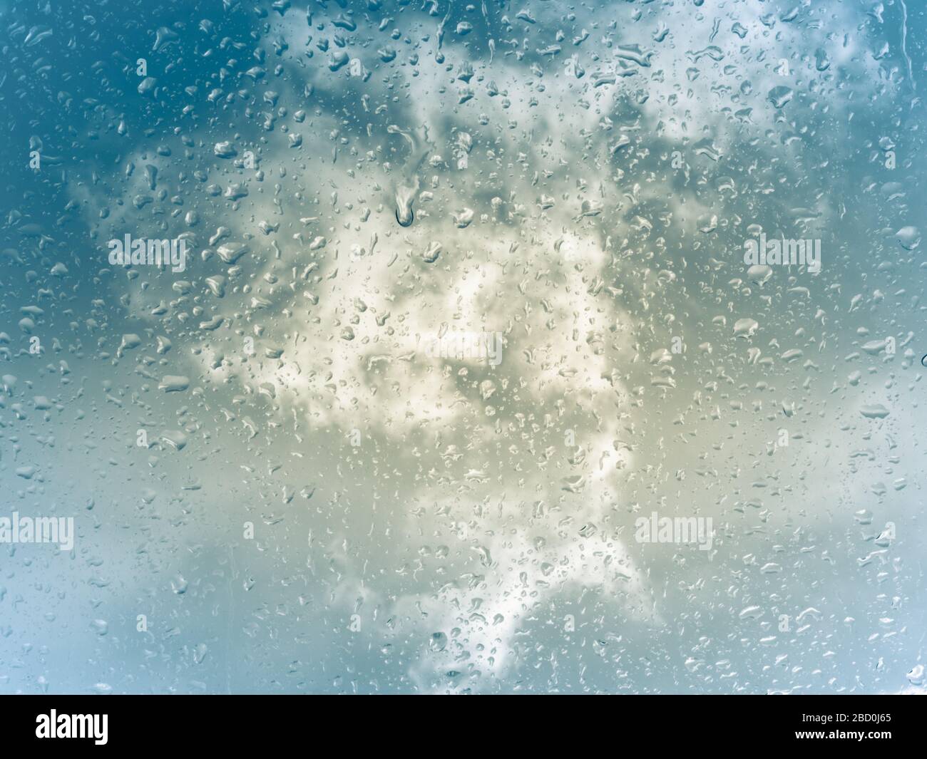 Wet window with rain drops and a cloudy sky outside background Stock ...