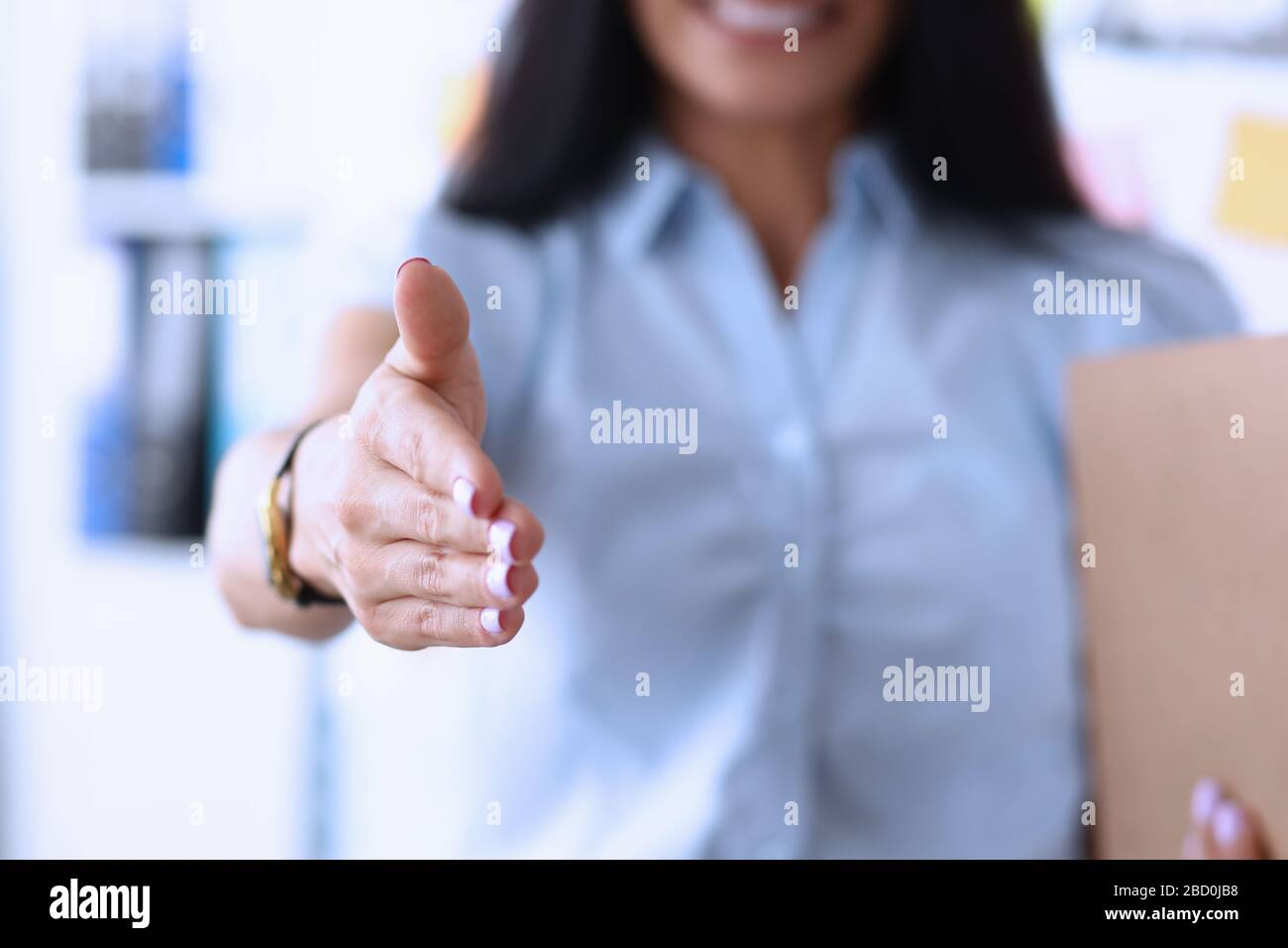 Smiling female manager giving hand to client Stock Photo - Alamy