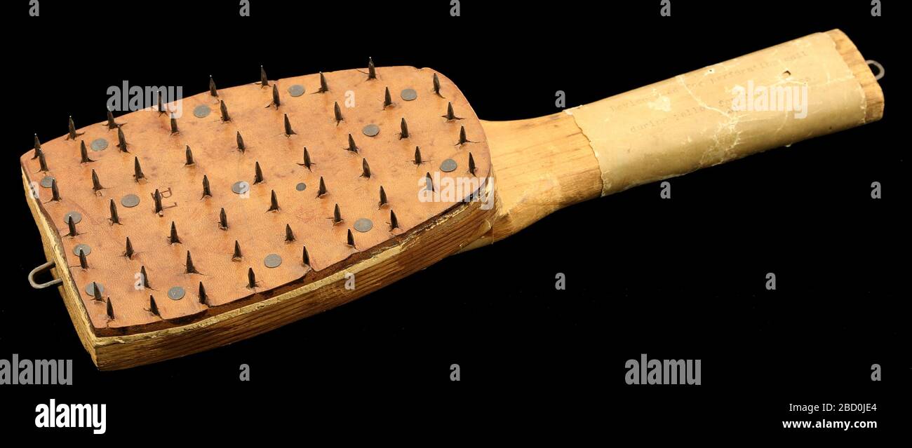 Perforating paddle. This unusual wooden paddle with a nail-studded ...